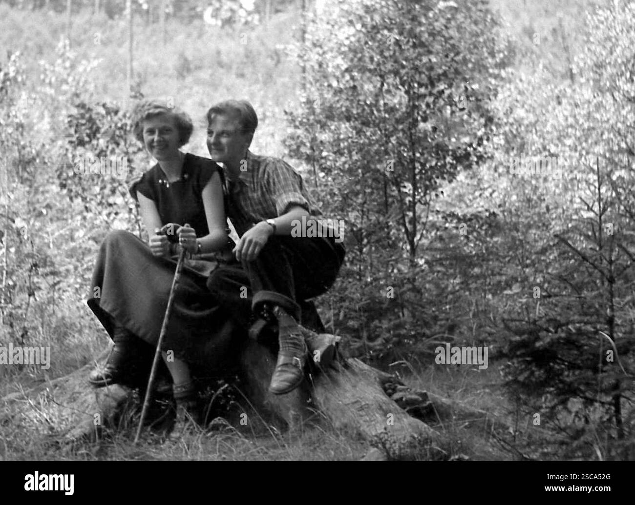 Couple on a tree stump taking a break in Saxon Switzerland Stock Photo ...