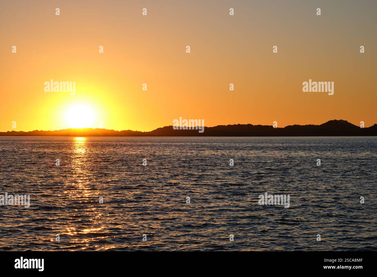 The sun setting over sand dunes at Leschenault Estuary in Australind, a ...