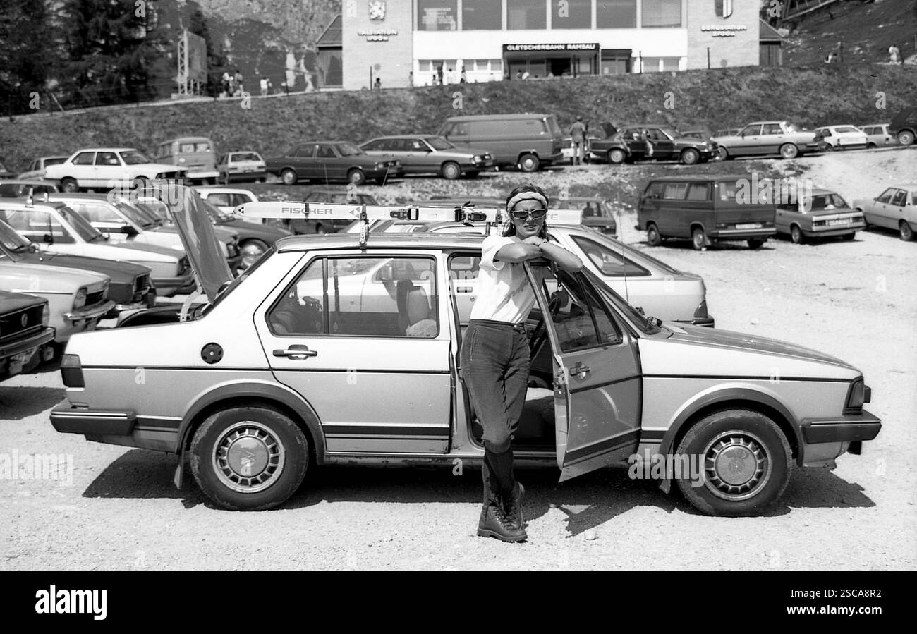 A woman is leaning against the open passenger door of a VW Jetta GTI on ...