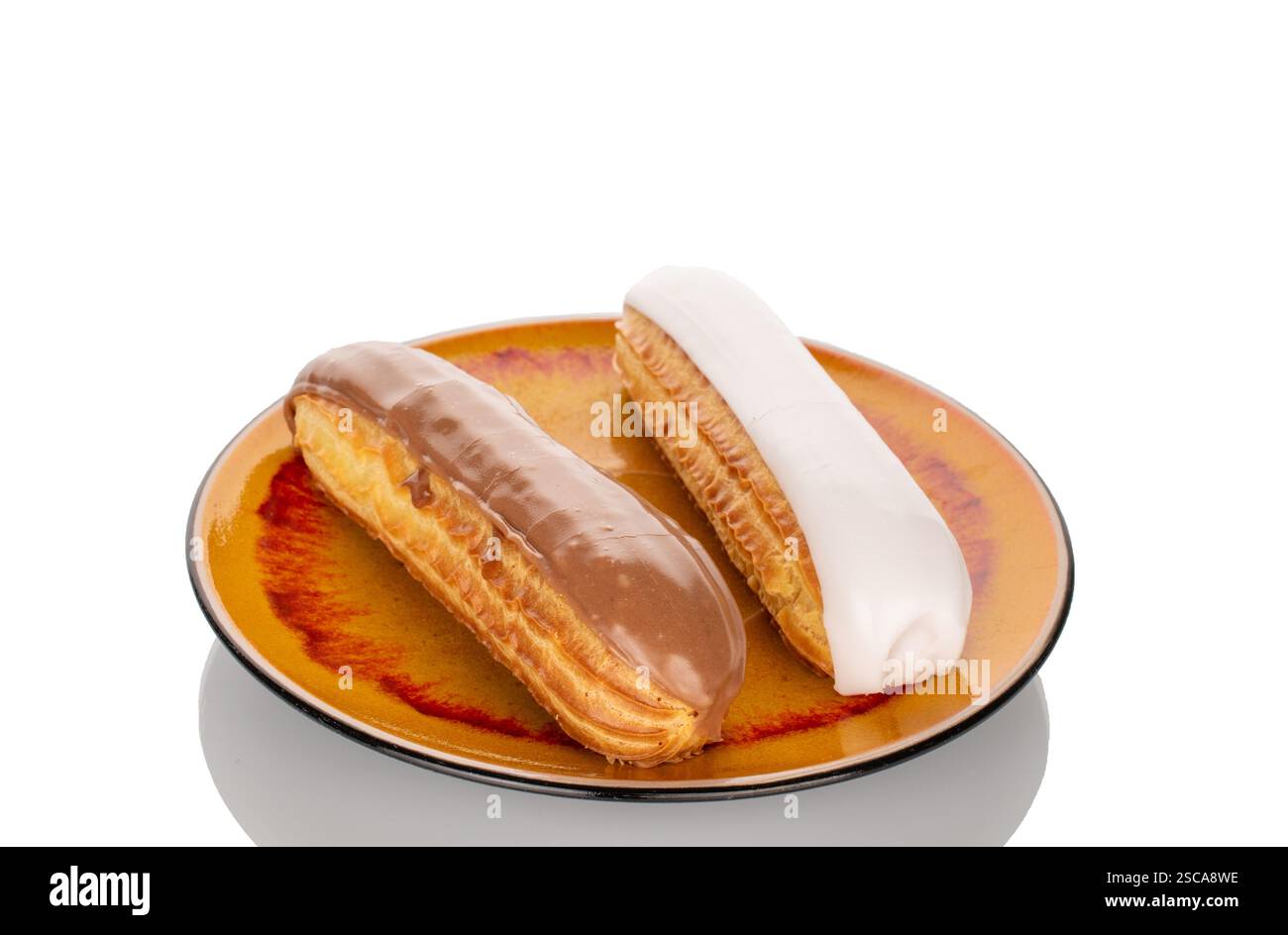Two eclairs with cream filling on a ceramic saucer, close-up, isolated ...
