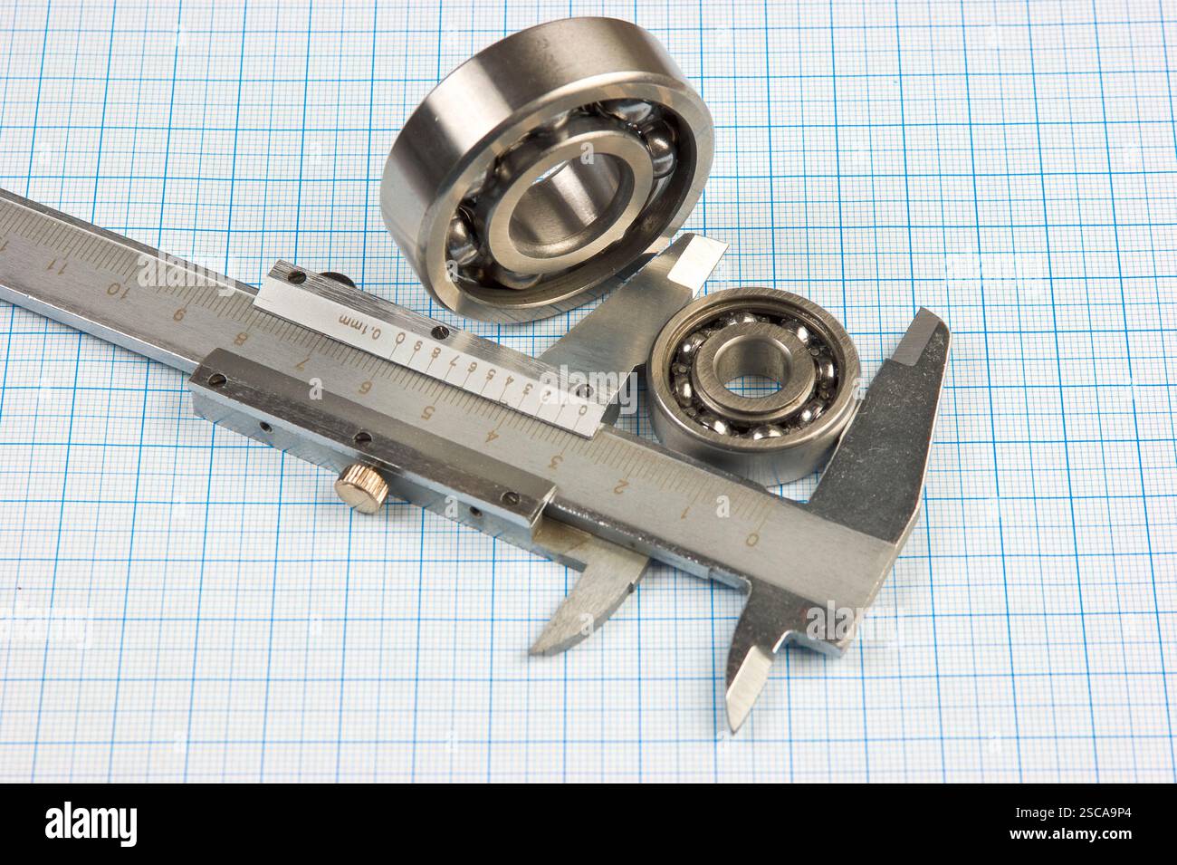 calipers, bearing and square on the background of graph paper Stock ...