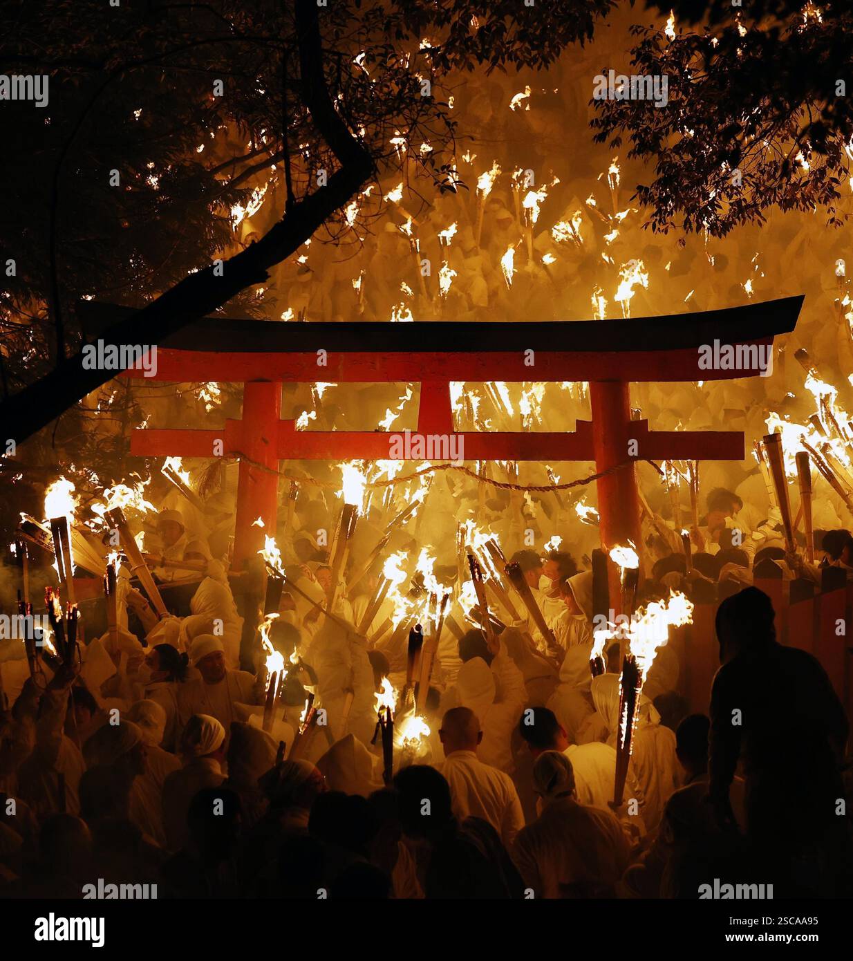 Men hold up burning torches during a traditional festival dating back ...