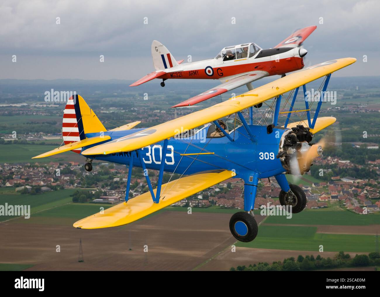 Stearman biplane and DHC-1 Chipmunk performing a formation flight in an ...