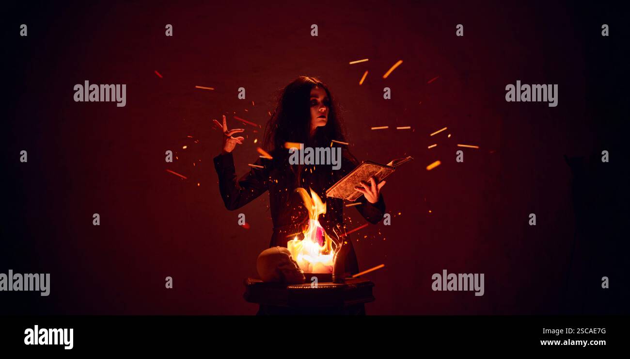 Terrifying woman with dark hair, with making spells with burning fire ...