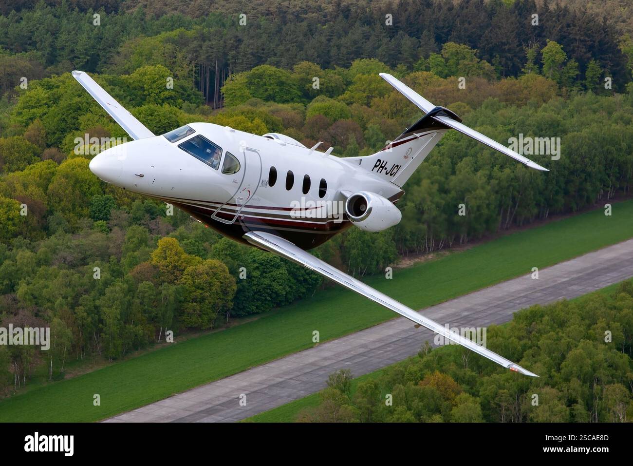 Embraer Phenom 100 business jet performing a high-speed maneuver during ...