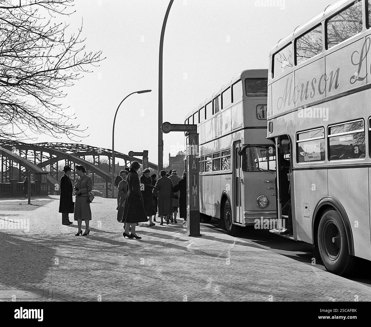 Double-decker-buses in Berlin-Halensee and passengers at a station ...