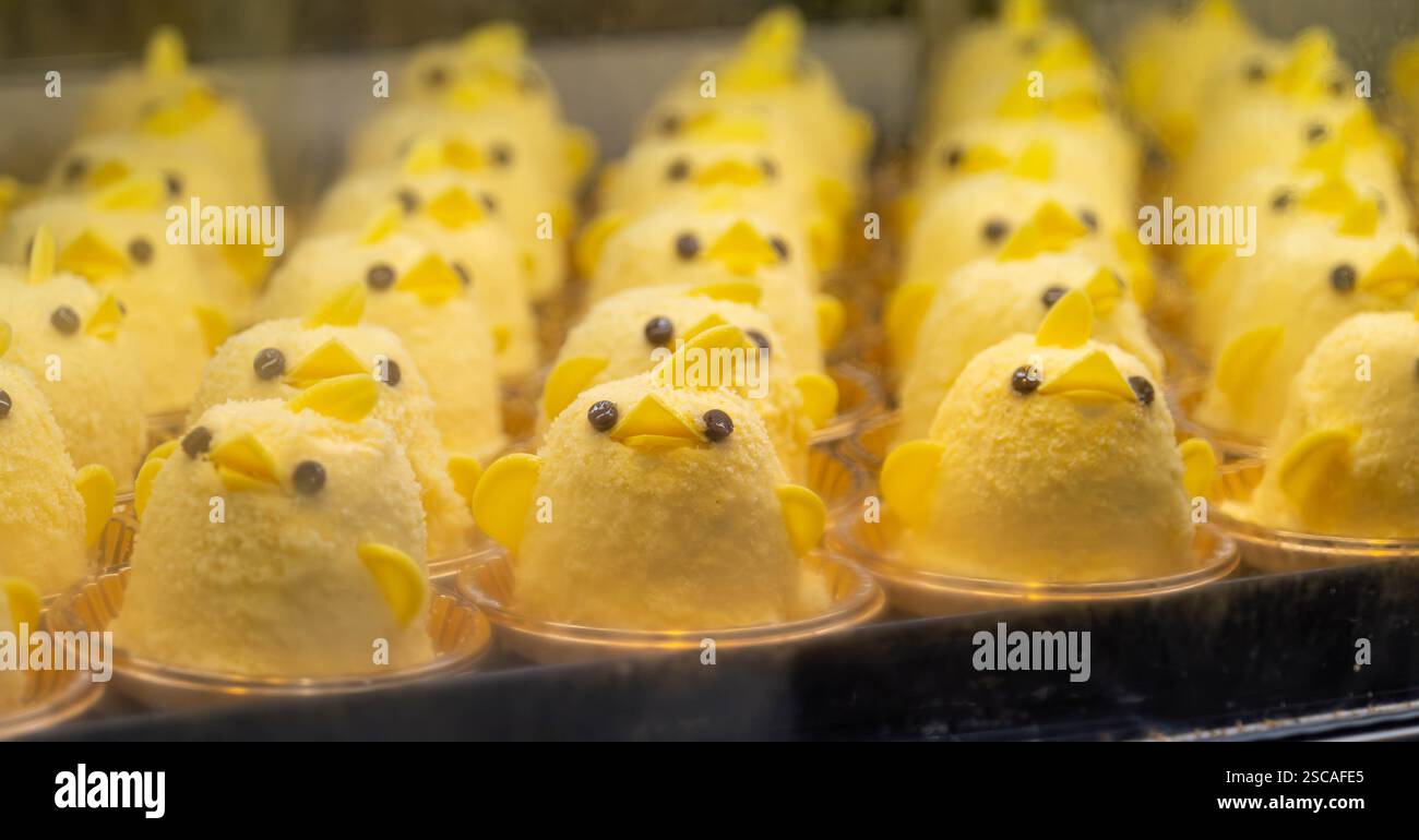A shot into a showcase of a row of yellow Nagoya chicken-shaped famous ...