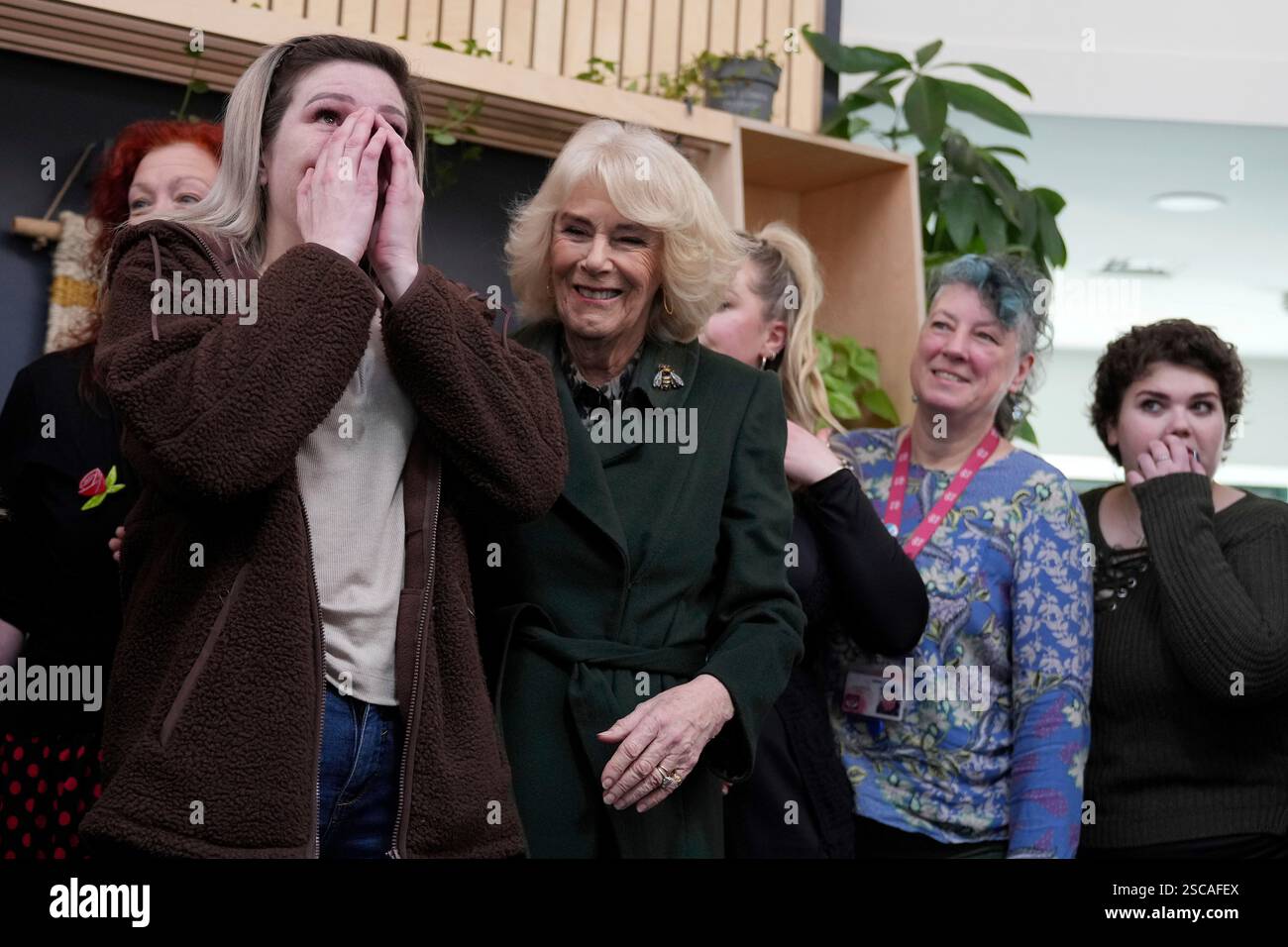 Britain's Queen Camilla comforts service user Sarah, left, as she ...