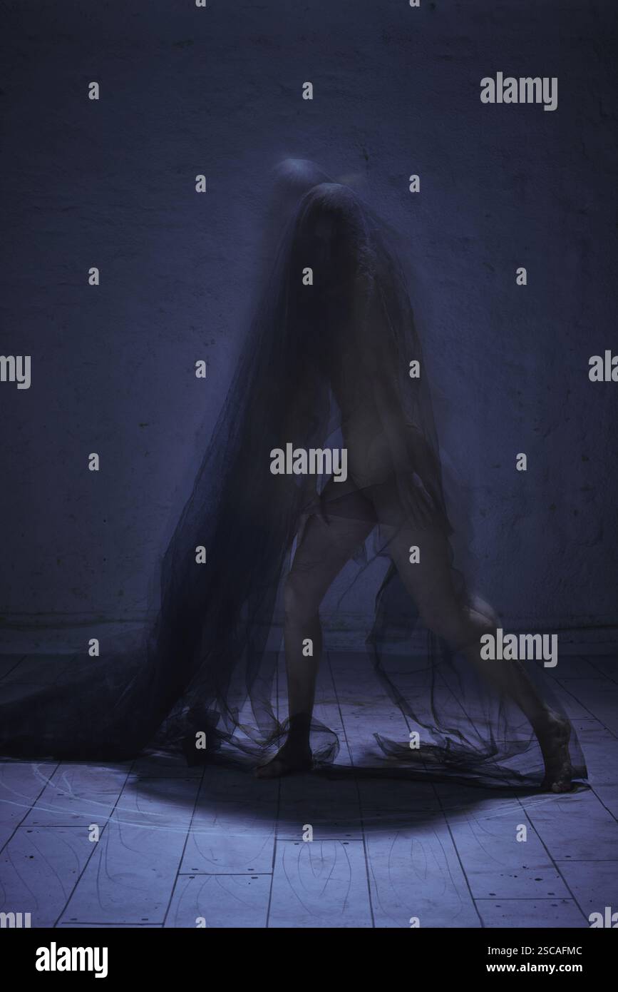 Horror scene with woman covered in dark veil, standing in a dynamic ...