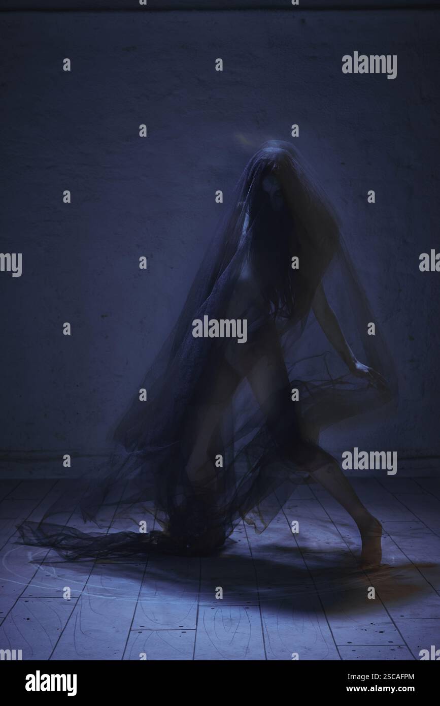 Horror scene with woman covered in dark veil, standing in a dynamic ...