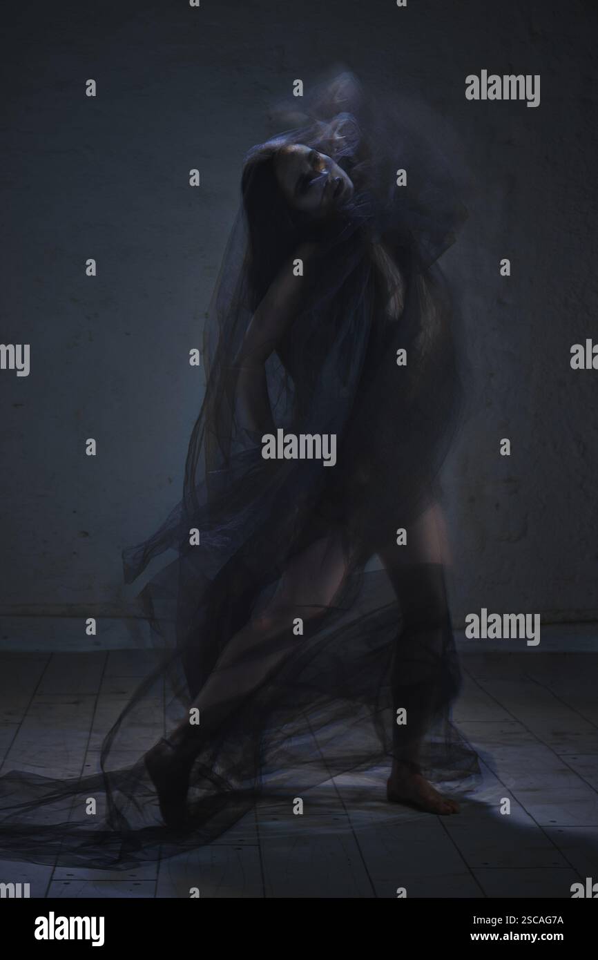 Horror scene with woman covered in dark veil, standing in a dynamic ...