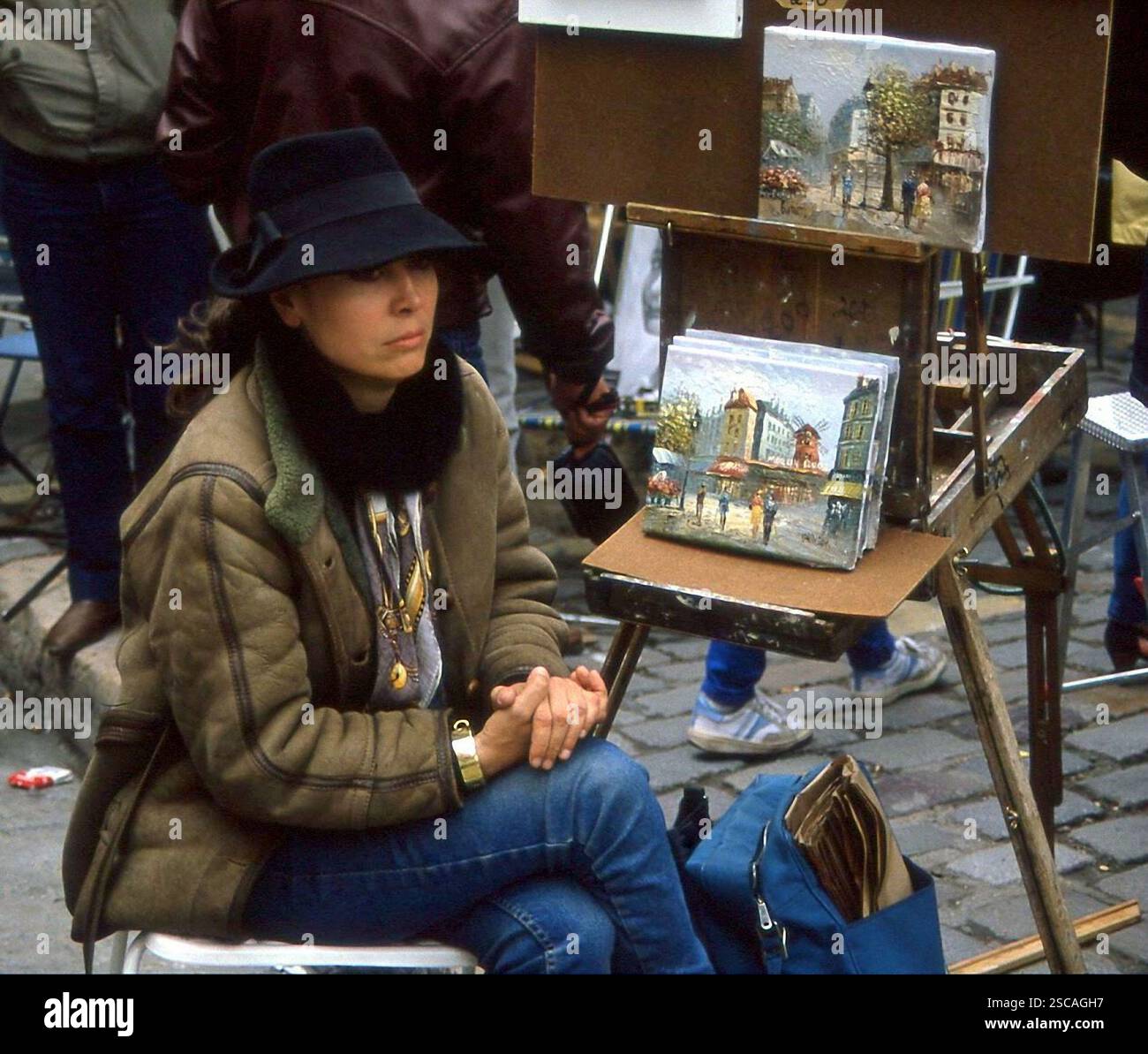 Painter wearing a coat and hat and paintings at the Place du Tertre in ...