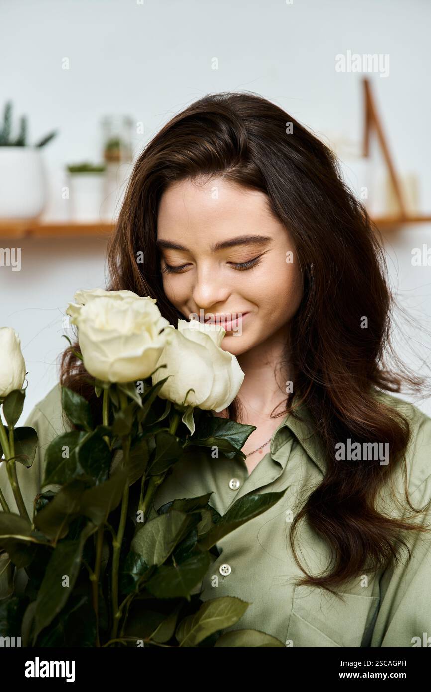 A beautiful young woman smiles softly while holding a bouquet of white ...