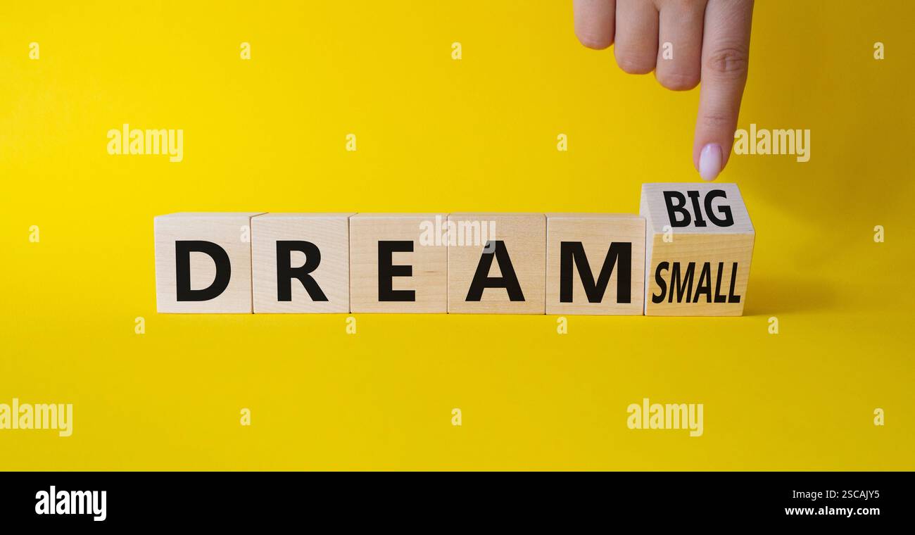Dream Big vs Small symbol. Businessman Hand points at wooden cubes with ...