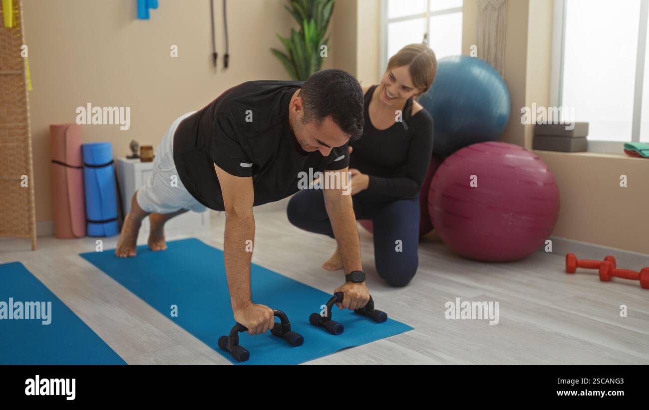Man and woman exercising together indoors at a gym with fitness ...