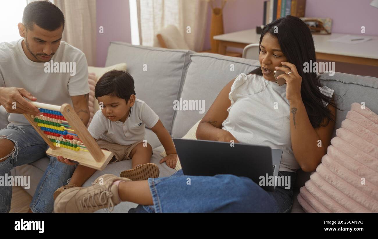 Mother multitasking on laptop and phone while father engages with their ...