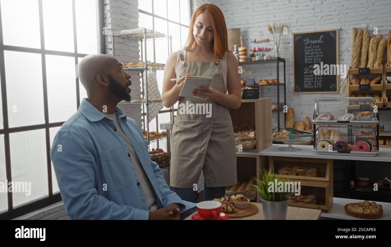 Woman taking order from man in bakery with shelves of bread and ...