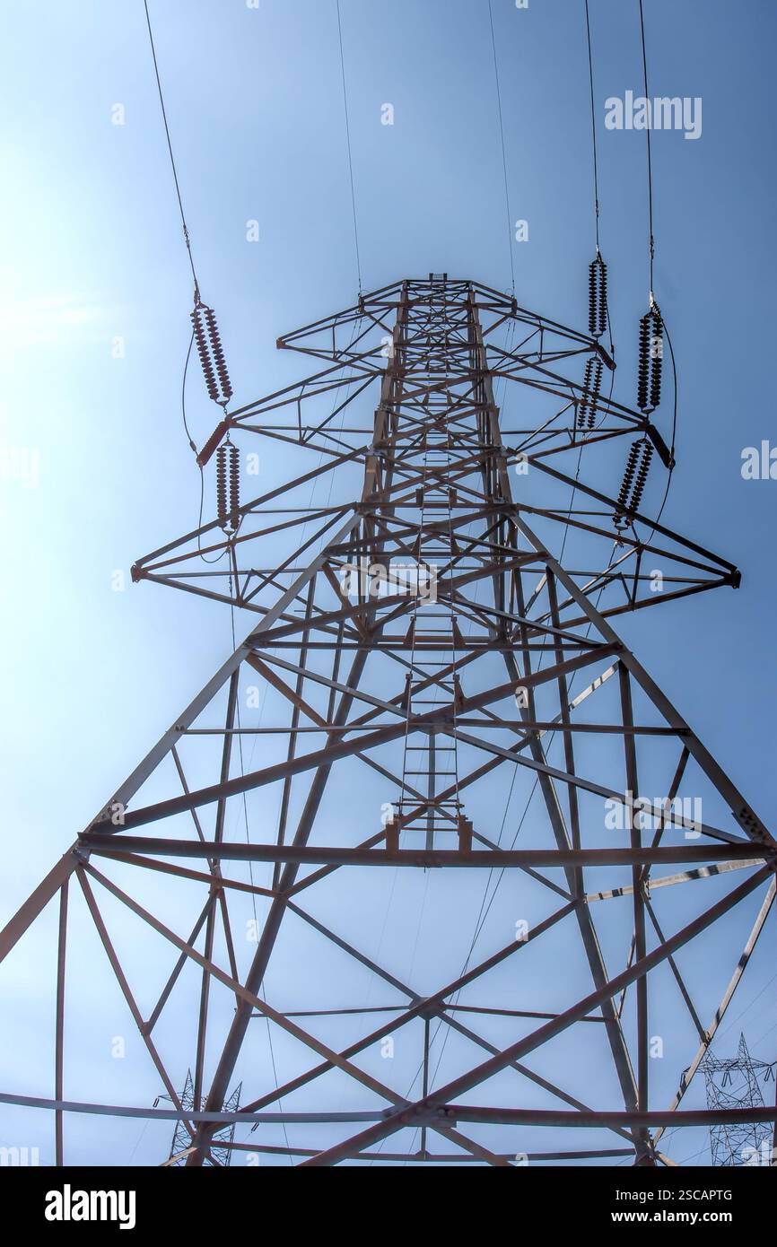 A tall power tower with a ladder on the side. The tower is surrounded ...