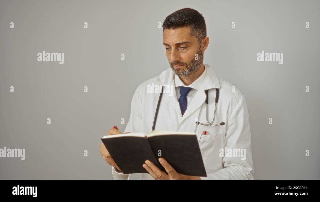 Doctor reading a book with a stethoscope around his neck, standing over ...