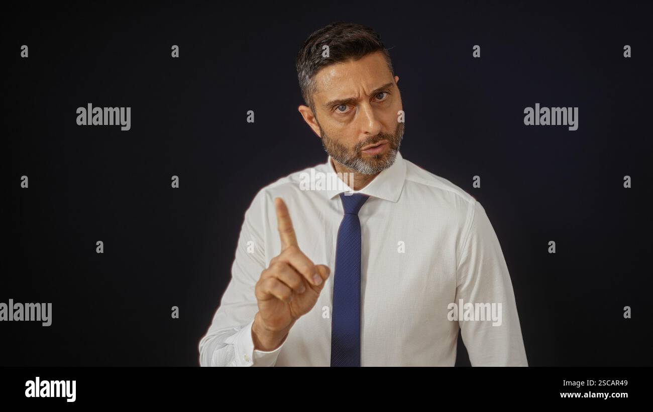 Serious man in shirt pointing finger in warning against a dark ...