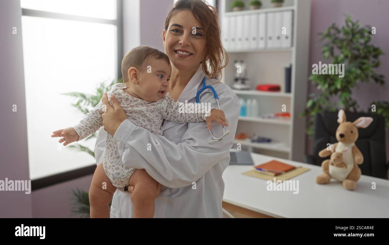 Female pediatrician holding baby in clinic room, showcasing ...