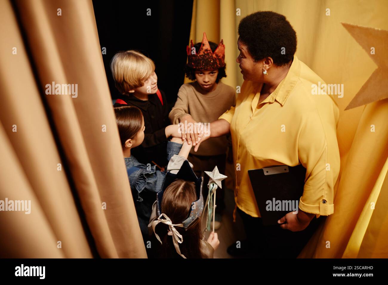 Educator wearing yellow shirt interacting with children involved in ...
