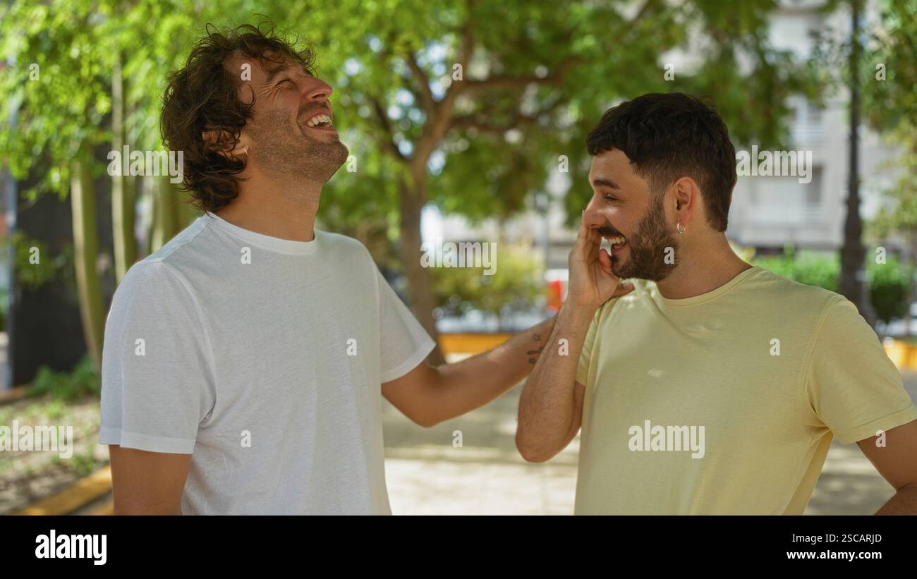 Two men laugh together under trees in an urban park, showcasing ...