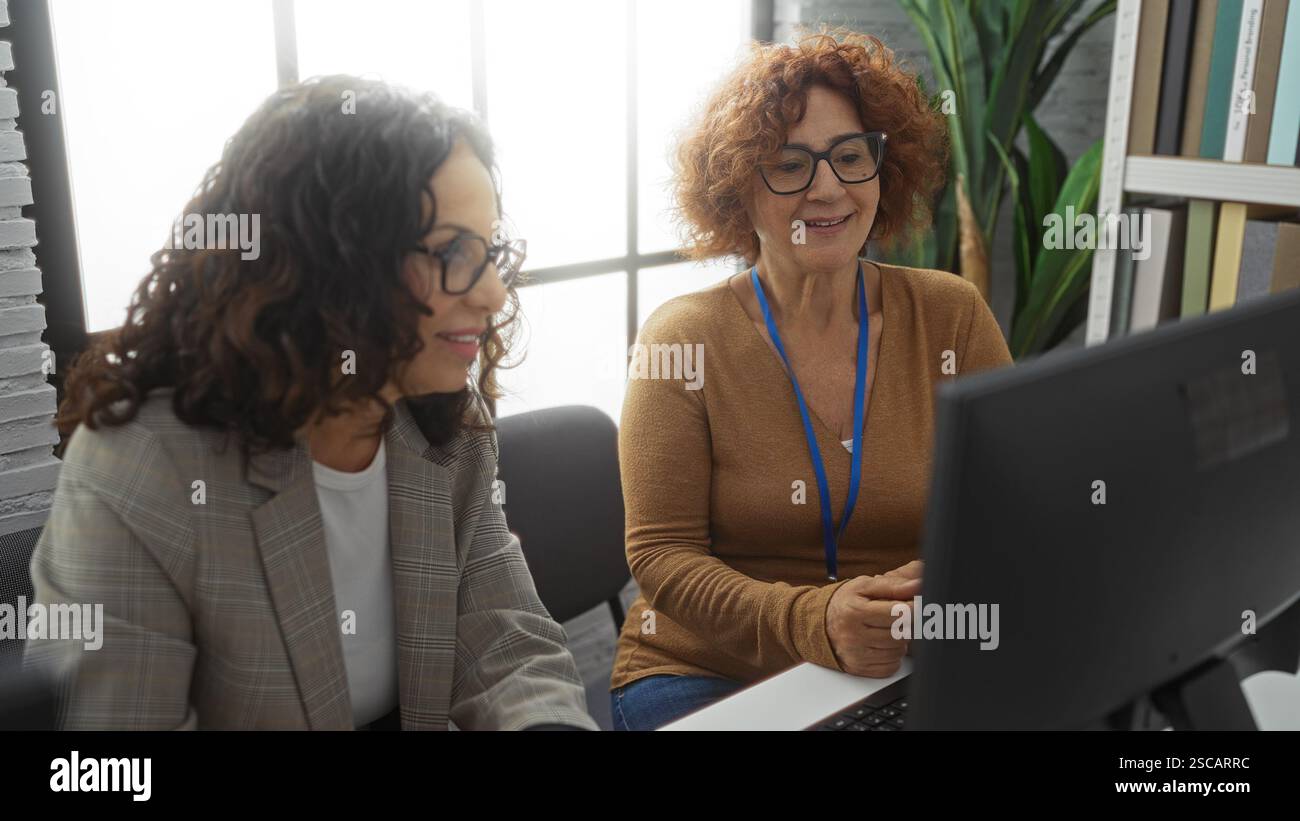 Two mature hispanic women colleagues working together in an office ...