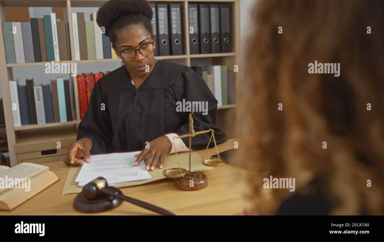 Woman judge in court office, discussing documents with another person ...