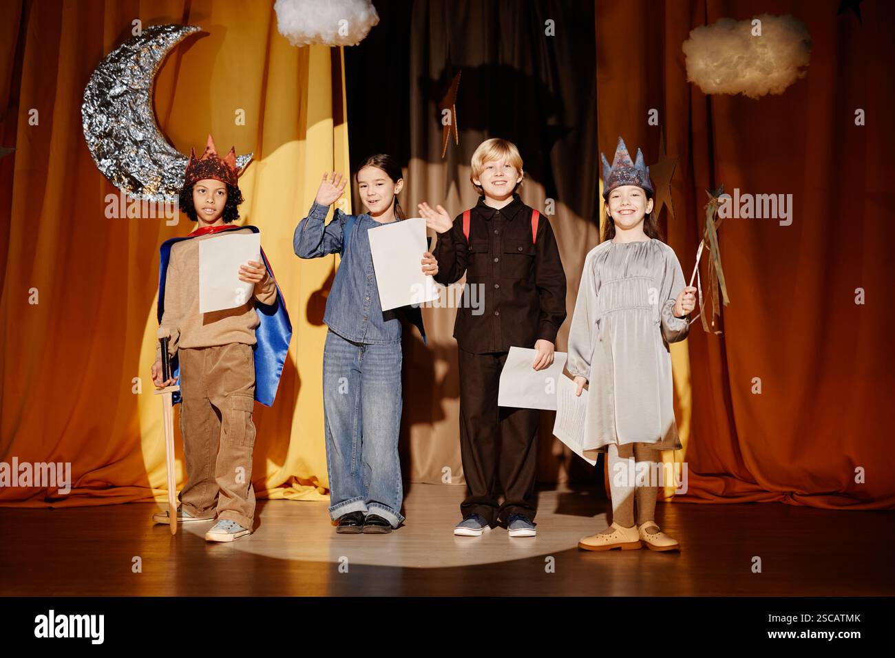 Four children on stage during a school play, holding scripts and ...
