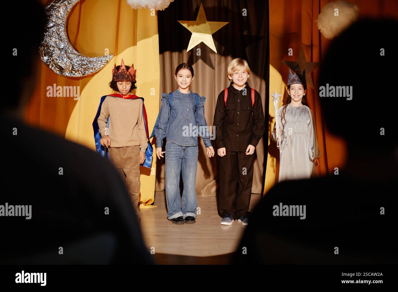 Group of children standing on stage during school play, wearing various ...