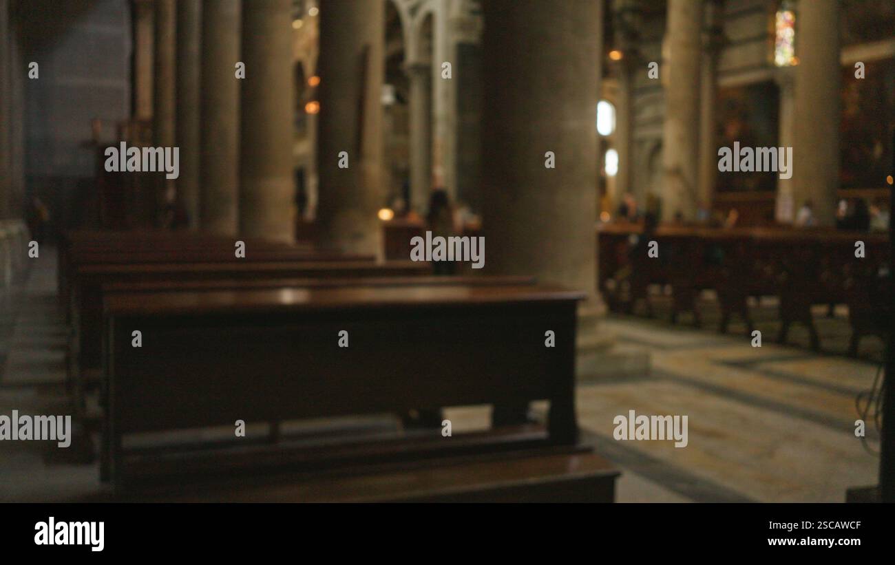 Blurred image of an empty church interior with benches and pillars ...