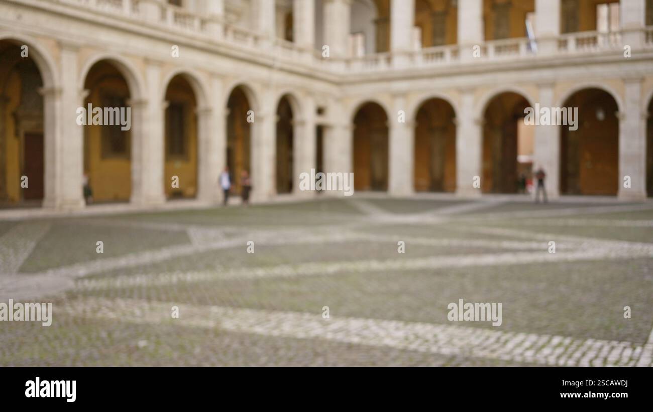 Blurry people walking on an historic university campus with an arched ...