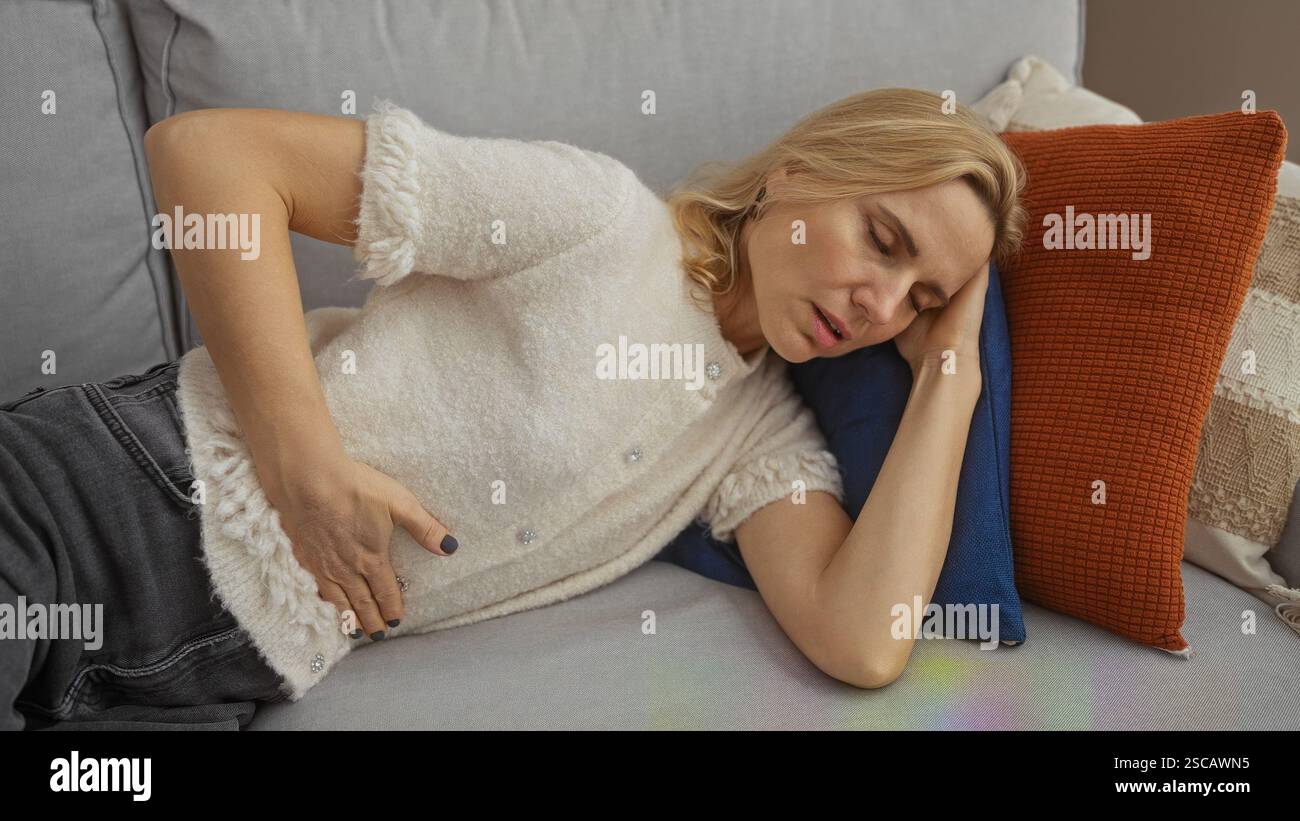 Woman resting on comfortable sofa in bright living room showing signs ...