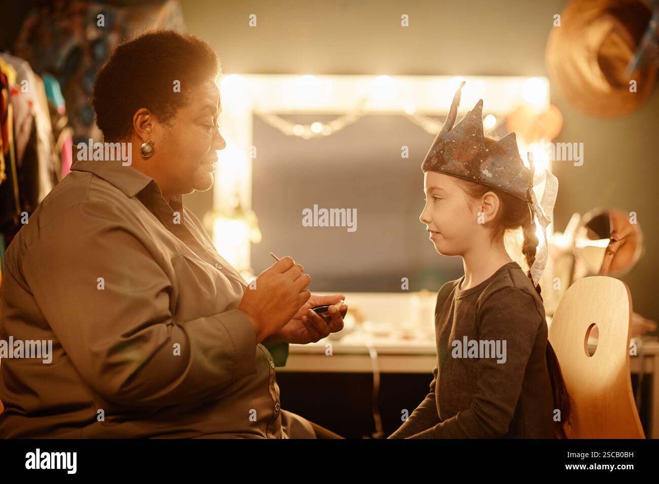 Woman engaging in conversation with young girl wearing a paper crown ...