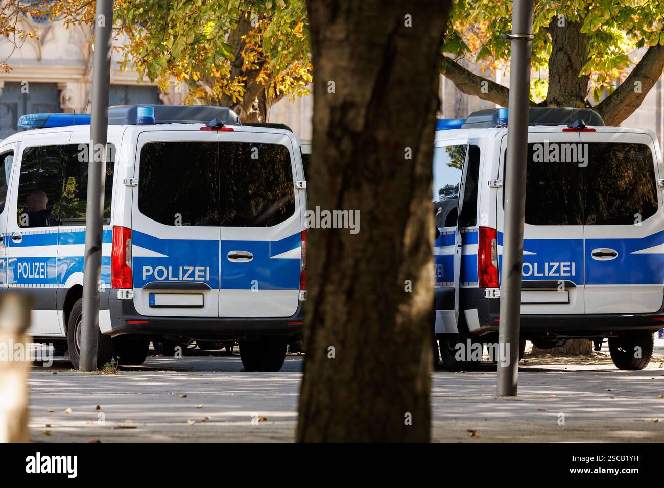 Scene back view many german police van cars serve at city street center ...