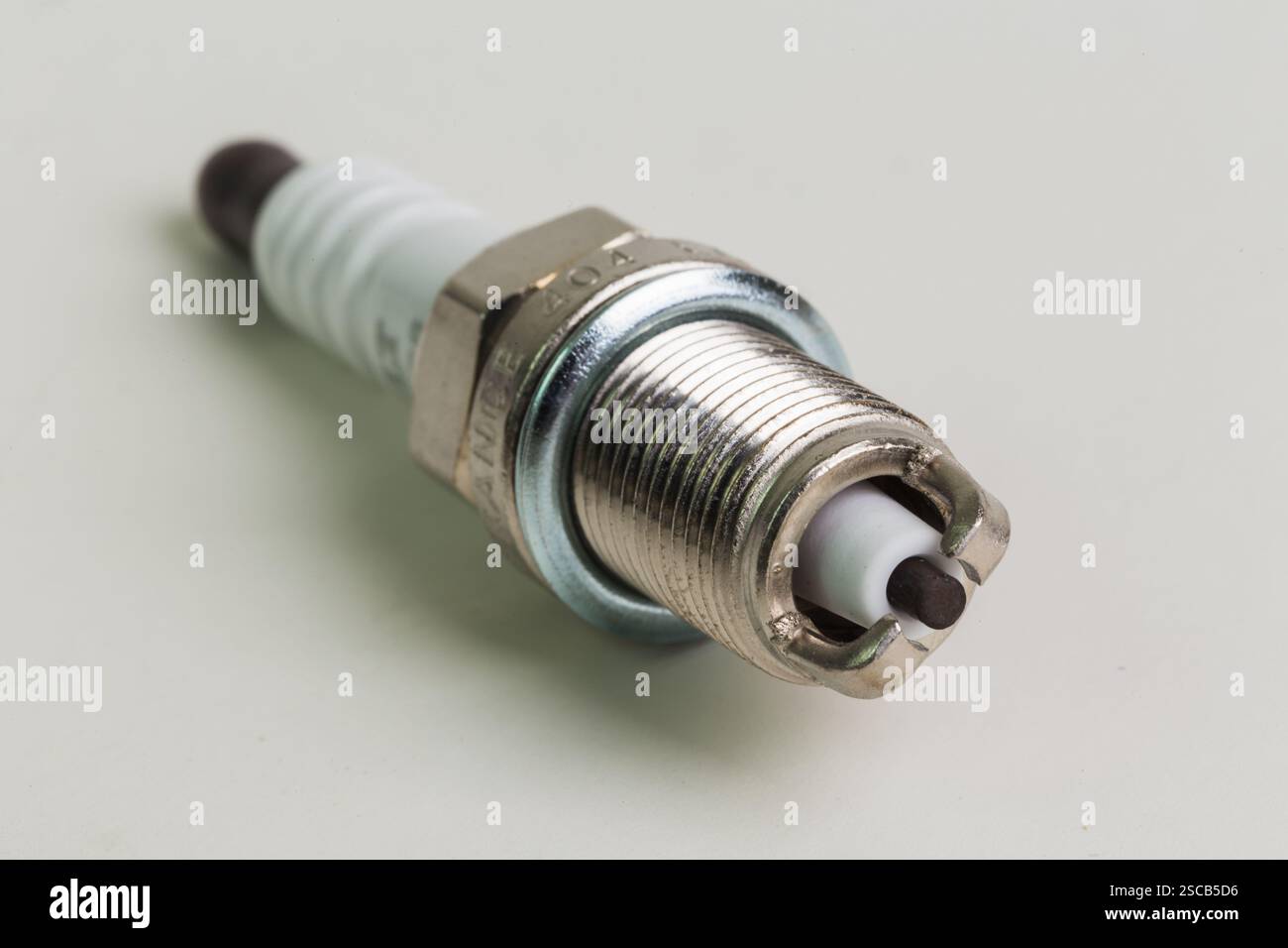 The sparking plug on a white background Stock Photo - Alamy
