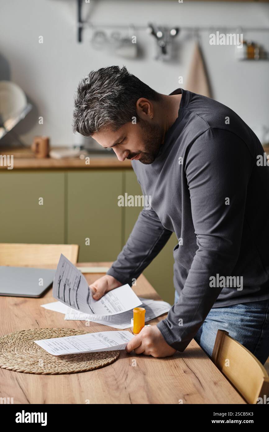 A handsome man carefully examines paperwork while standing at a modern ...