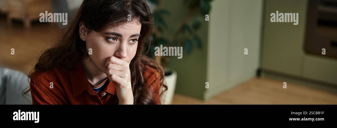 A woman sits quietly, lost in thought, reflecting on her inner turmoil ...