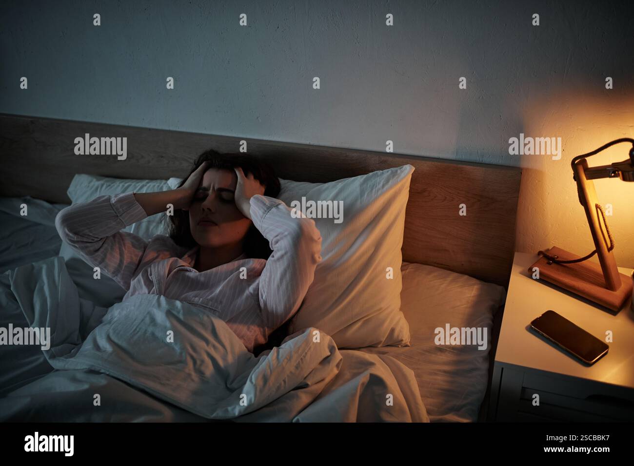 A woman lies in bed, overwhelmed by emotions, grappling with feelings ...