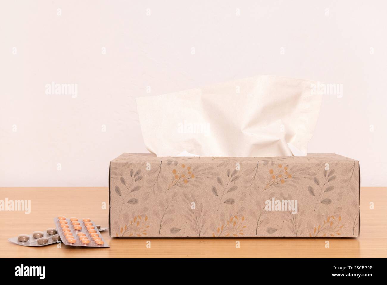 A box of tissues and a stack of pills on a table Stock Photo - Alamy