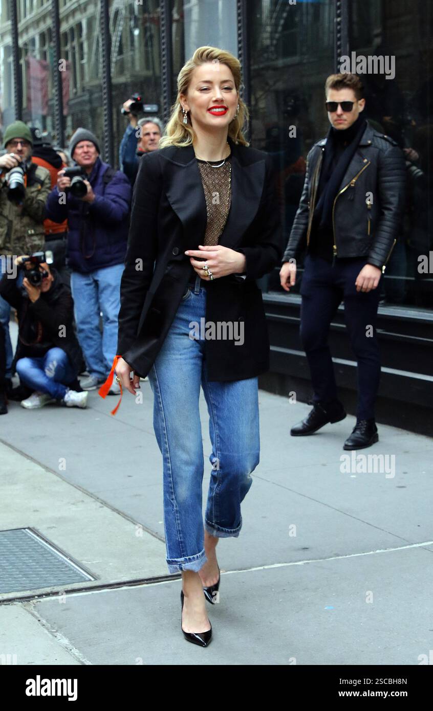Actress Amber Heard sports an orange ribbon on her wrist as she arrives ...