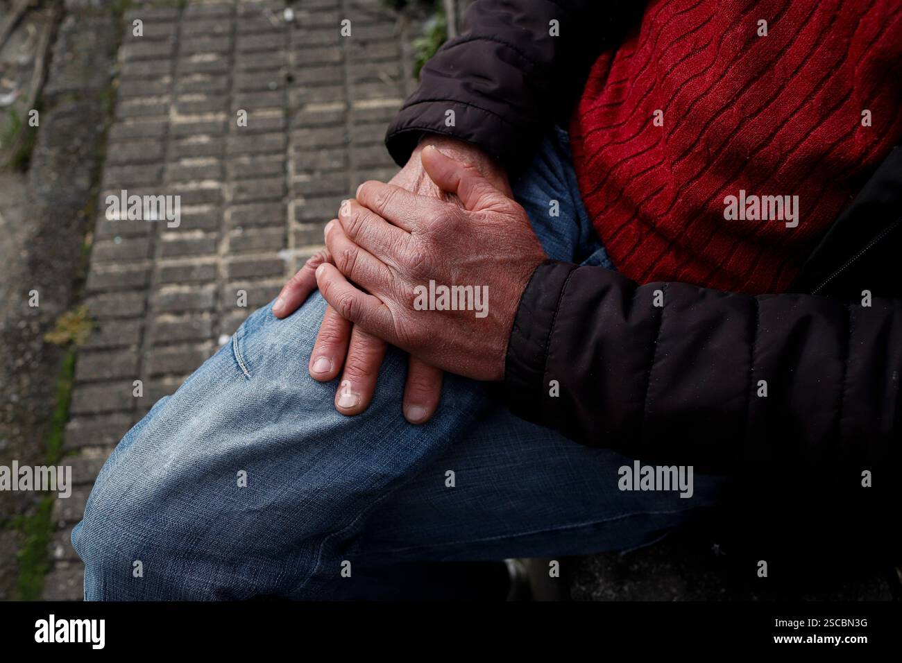 The hands of a homeless person at the old bus station in Vigo, on ...