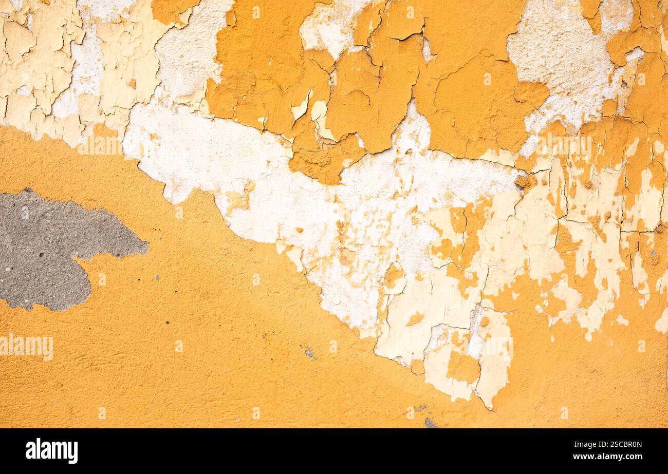 Yellow concrete wall with natural defects: faults, cracks, chips ...