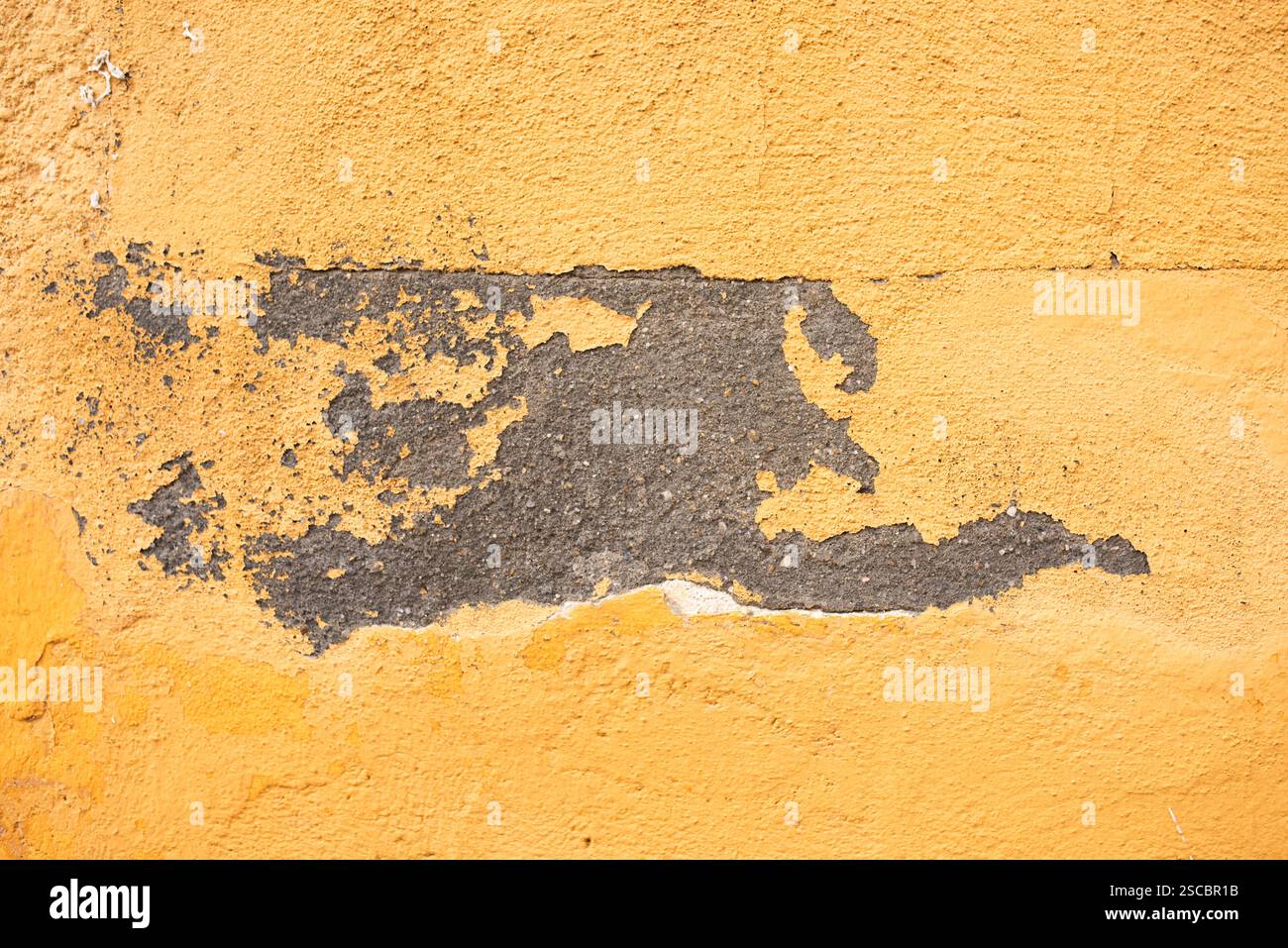 Yellow concrete wall with natural defects: faults, cracks, chips ...