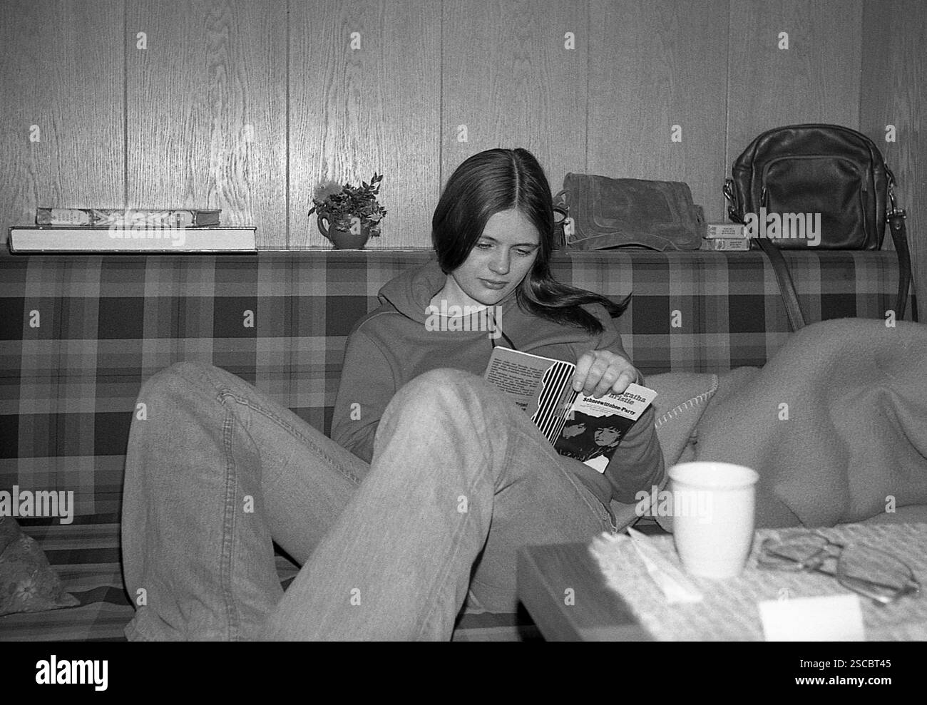 A young woman was reading a book by Agatha Christie. [automated ...