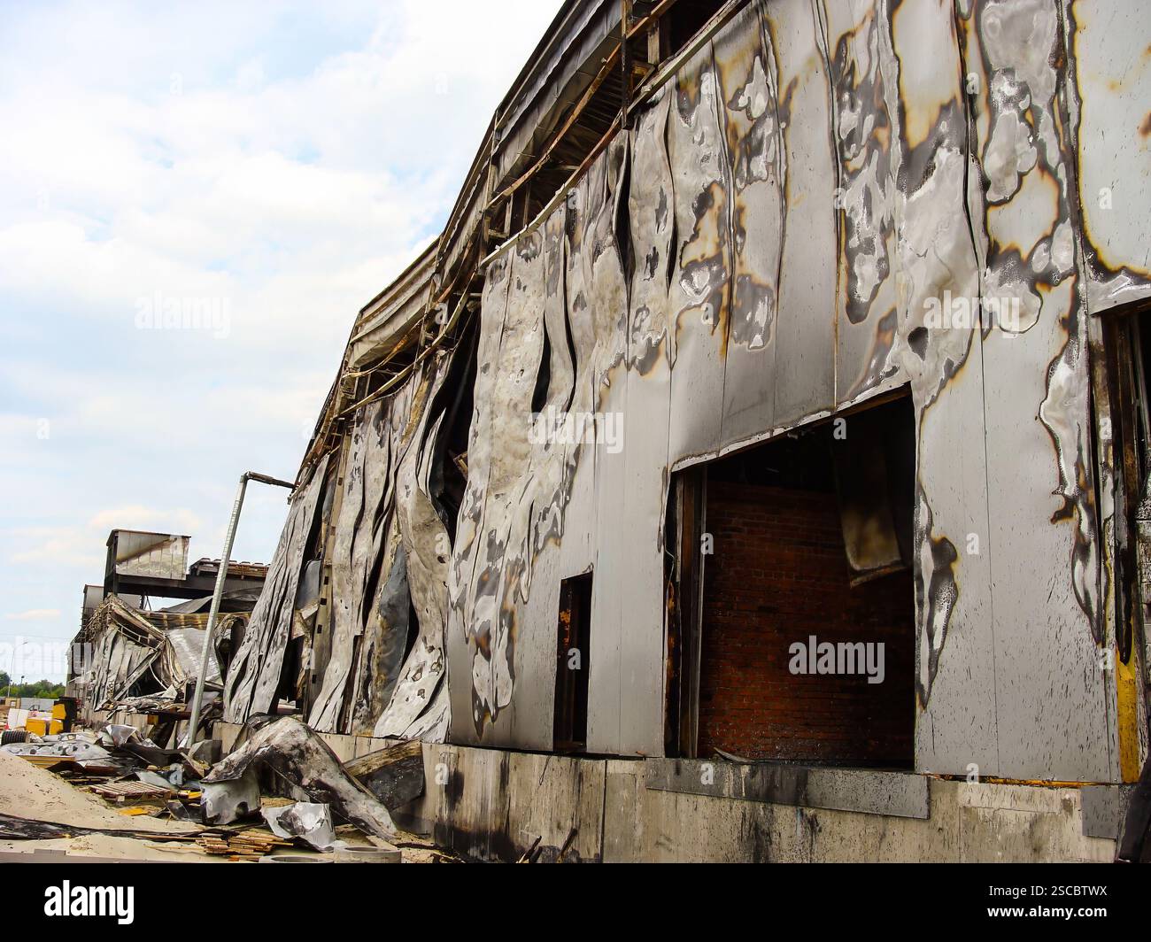 Burnt warehouse with melted sandwich panels, showing severe fire damage ...