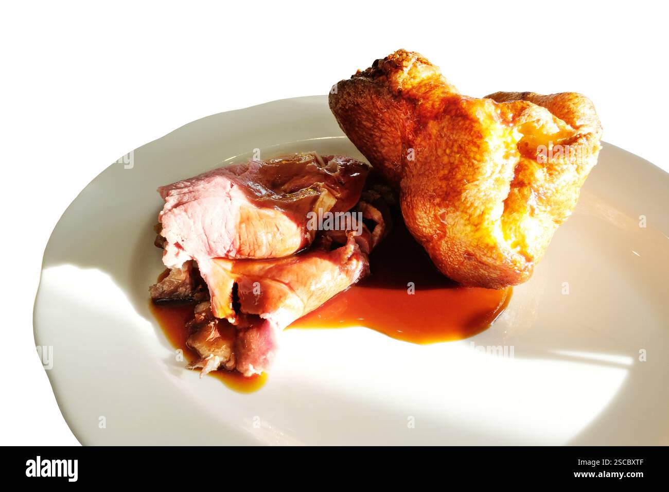 Slices of roast rib of beef and yorkshire pudding cut out against a ...