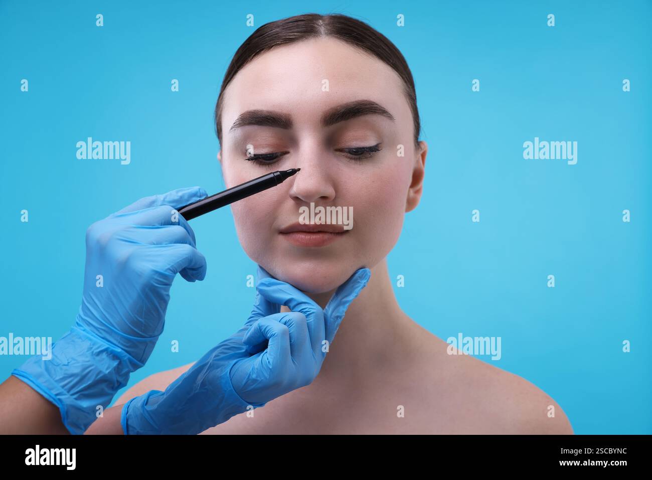 Doctor drawing marks on patient's nose for plastic surgery operation ...