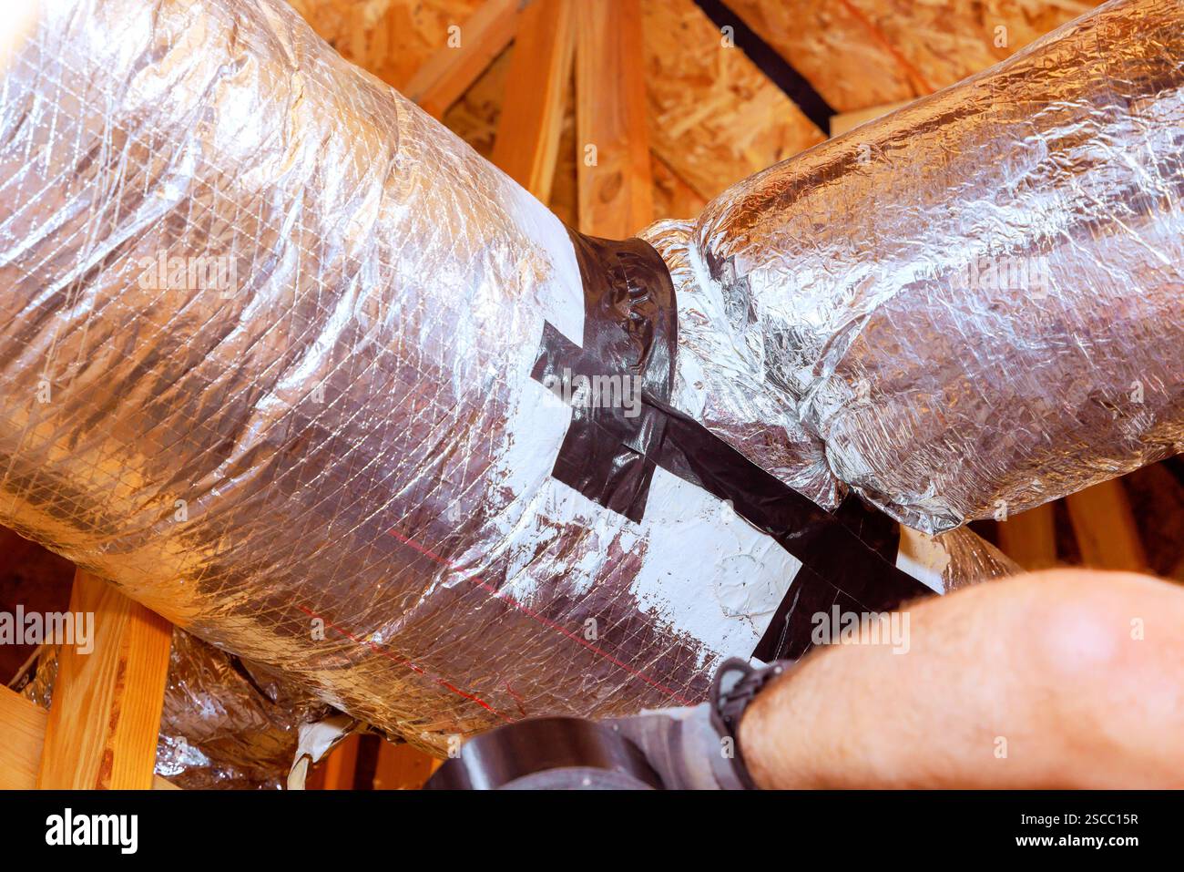 Workers are securing insulated ductwork in residential attic, ensuring ...